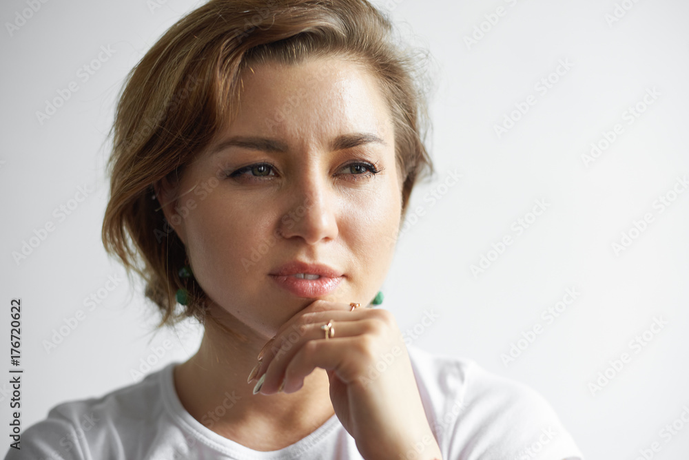 Attractive young woman pondering, deep in thoughts, expressing doubt ...