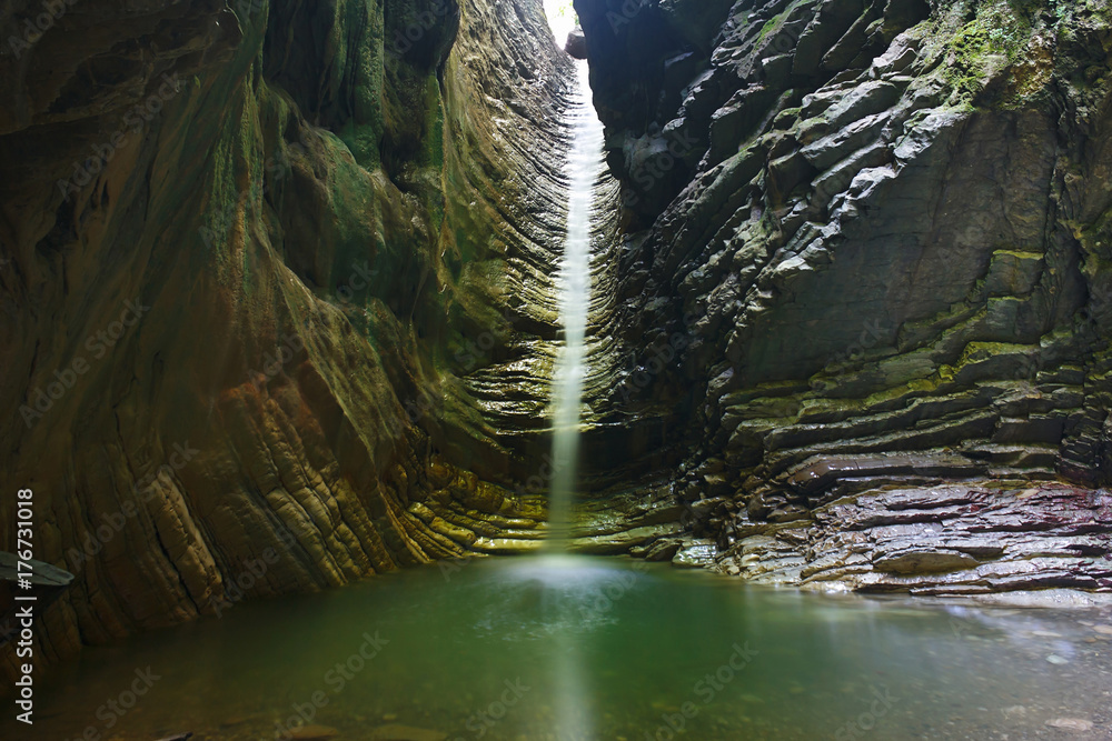 Beautiful grotto with a pouring beautiful waterfall Stock Photo | Adobe ...