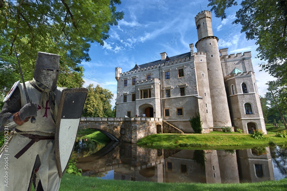 Templar knight with neo-Gothic style castle surrounded by a moat in ...