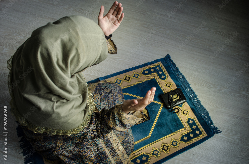 Muslim woman praying for Allah muslim god at room near window. Hands of ...