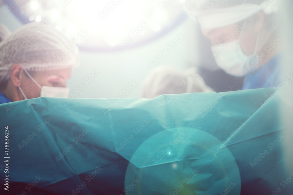 Medical background with team of surgeons doctors illuminated by special ...