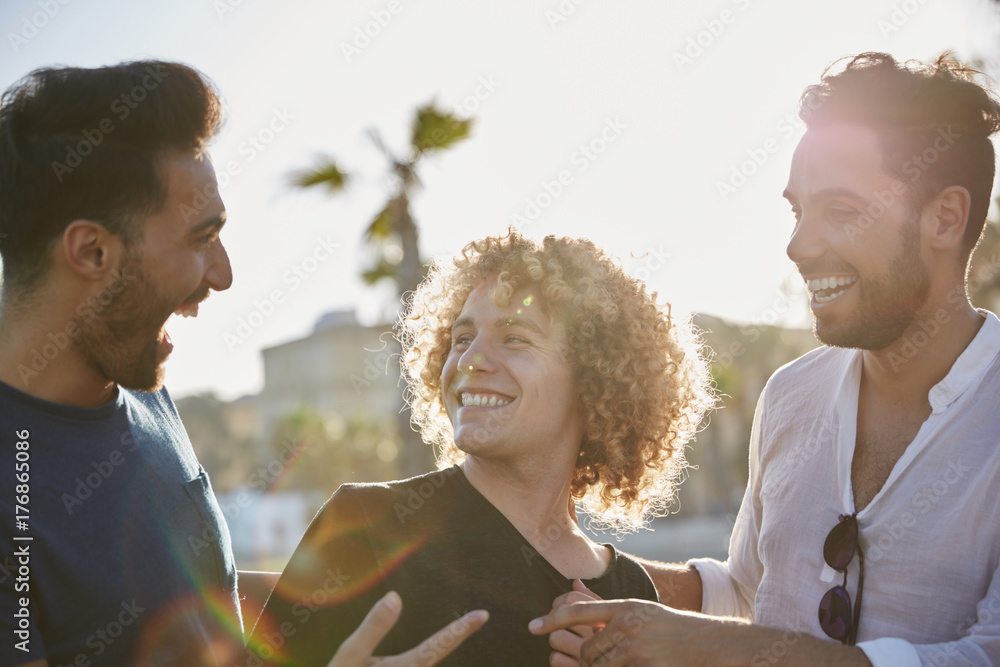 Three happy men standing together outside laughing Stock Photo | Adobe ...