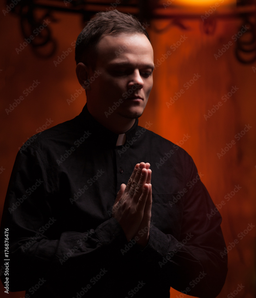 Portrait of handsome catholic priest or pastor with dog collar, dark ...