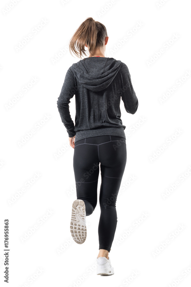 Rear backside view of female runner in hooded sweatshirt running away ...
