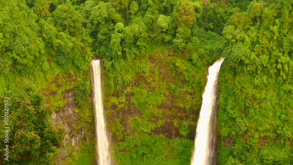 Waterfall in reverse. Water flowing up a twin waterfall in a tropical ...