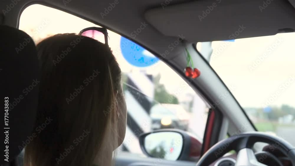 blond girl driving a car, gorgeous sun flare and grading. Occasional ...