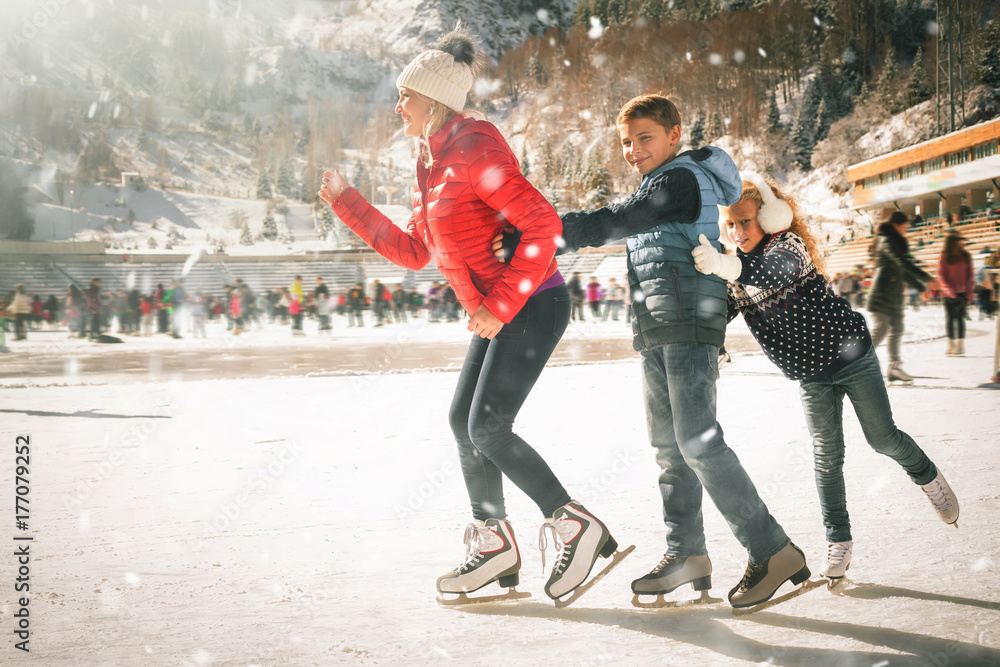 Happy family outdoor ice skating at rink. Winter activities Stock Photo ...