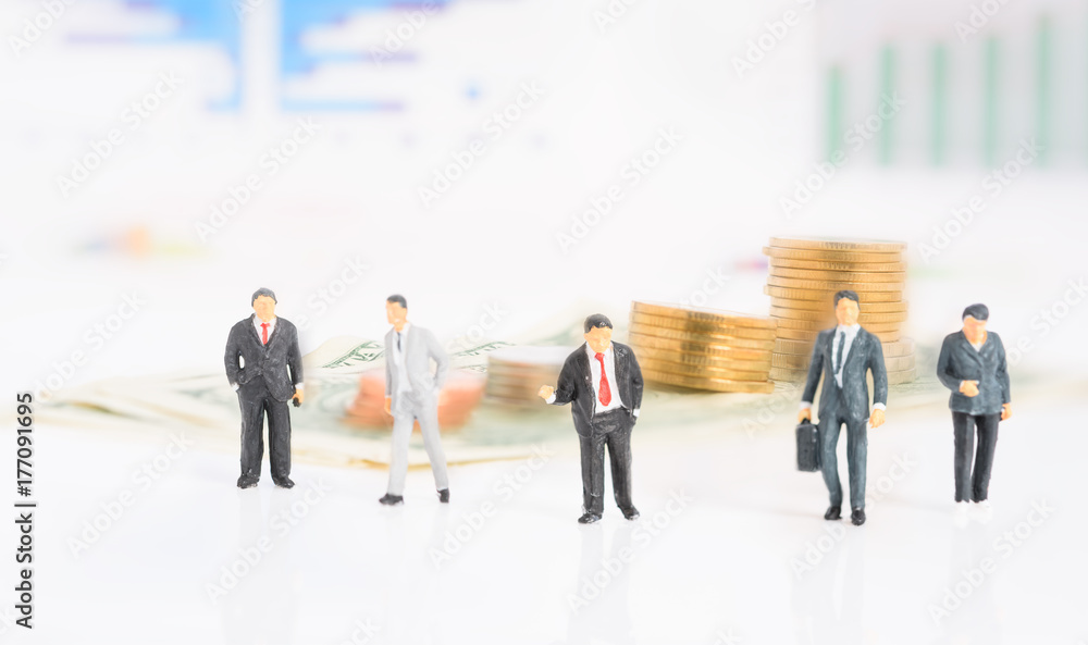 Miniture success businessman team work meeting with coins and graph ...