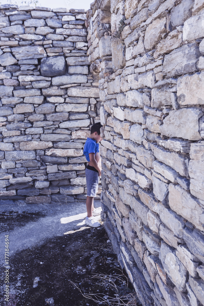 Boy pissing on a stoned wall Stock Photo | Adobe Stock