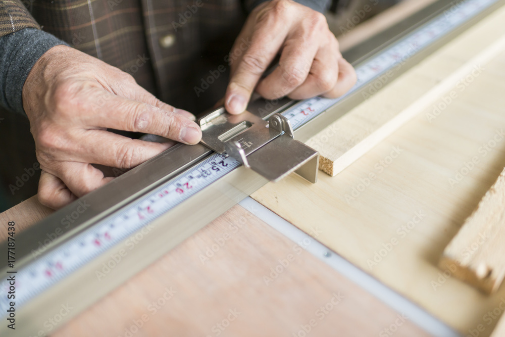Man Measures Wood on Table Saw Stock Photo | Adobe Stock