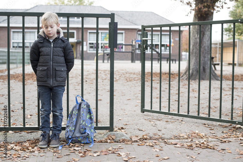 Young sad boy waiting at school for his mother Stock Photo | Adobe Stock