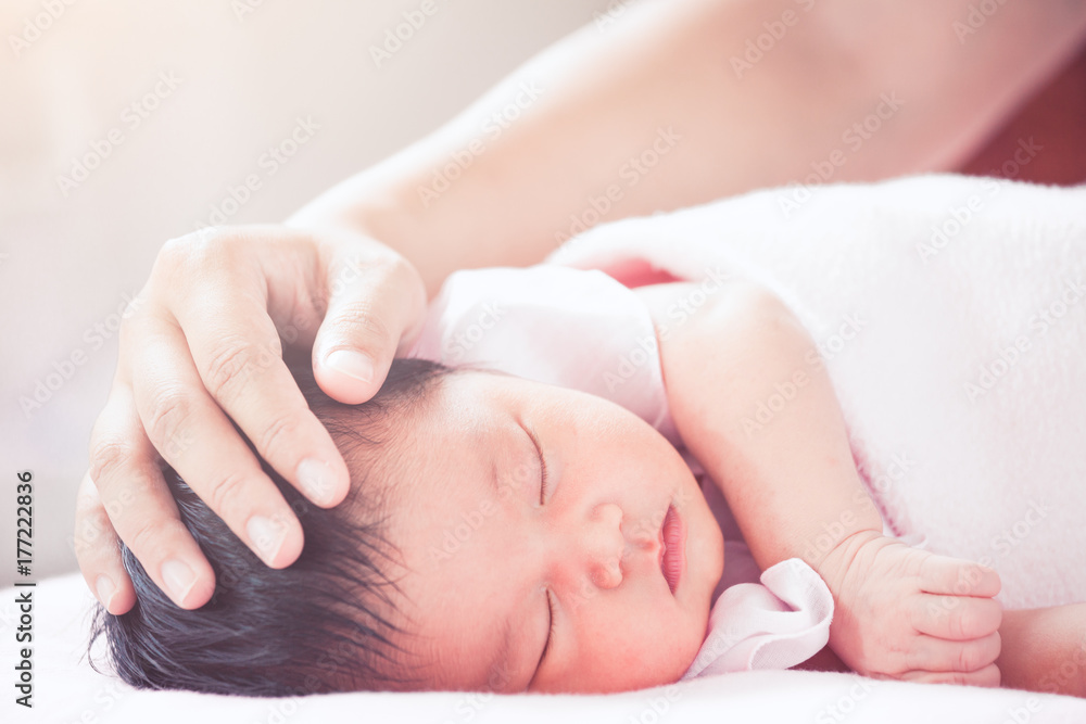 Mother hand touching asian newborn baby girl head while she sleeping ...