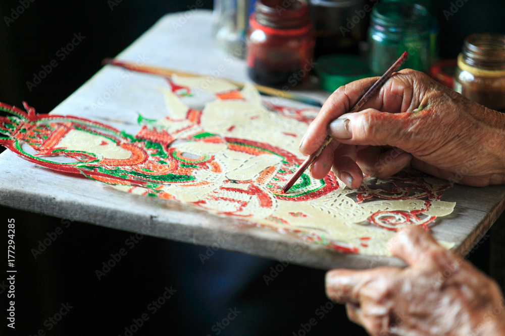 old lady painting color into shadow play character with intend Stock ...