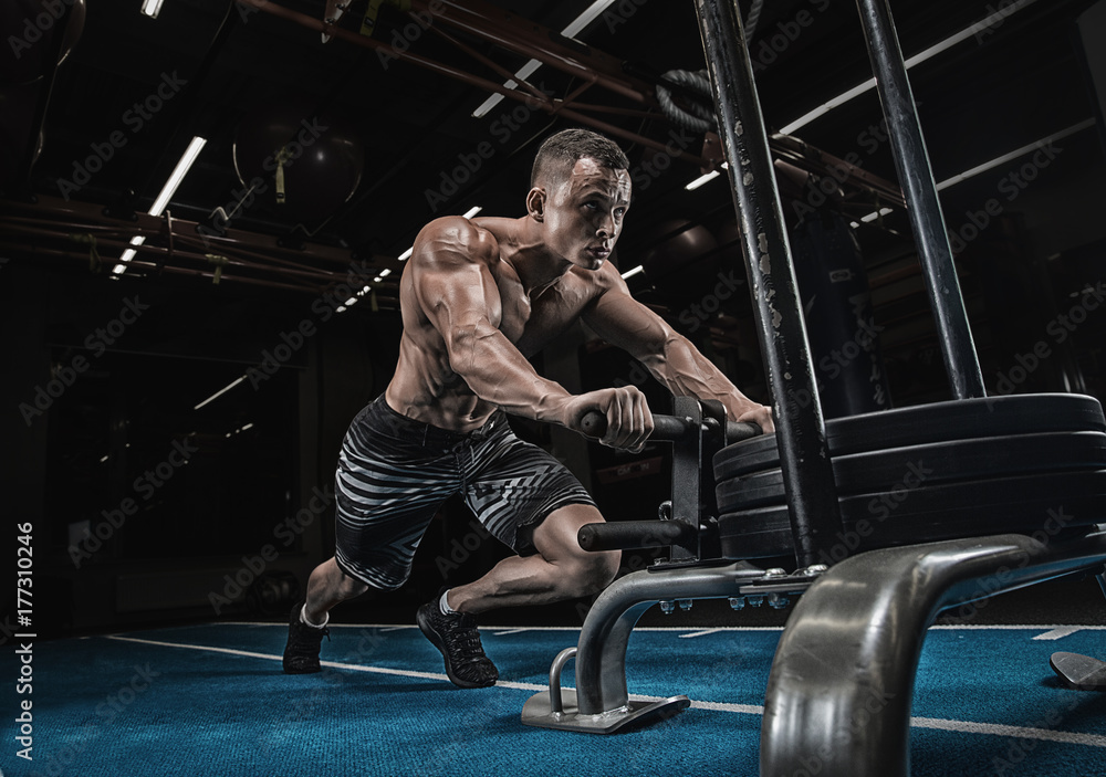 Fitness sled push man pushing weights workout exercise Photos | Adobe Stock