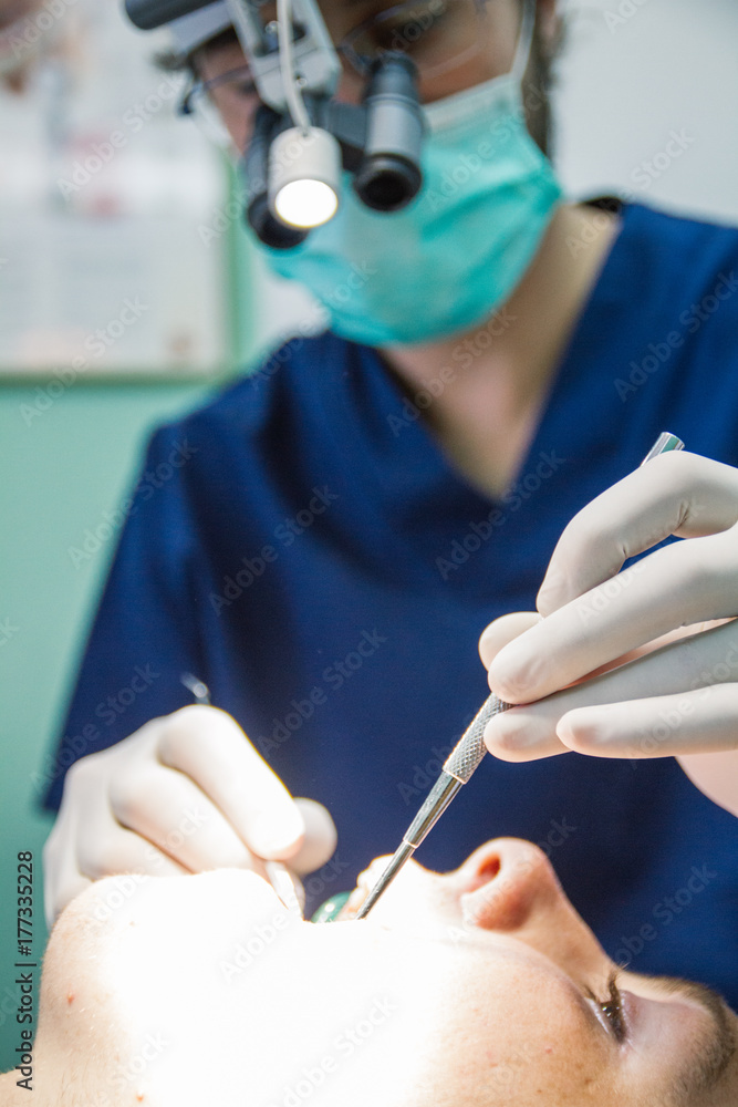 Dentist with microscope glasses during a root canal intervention Stock ...