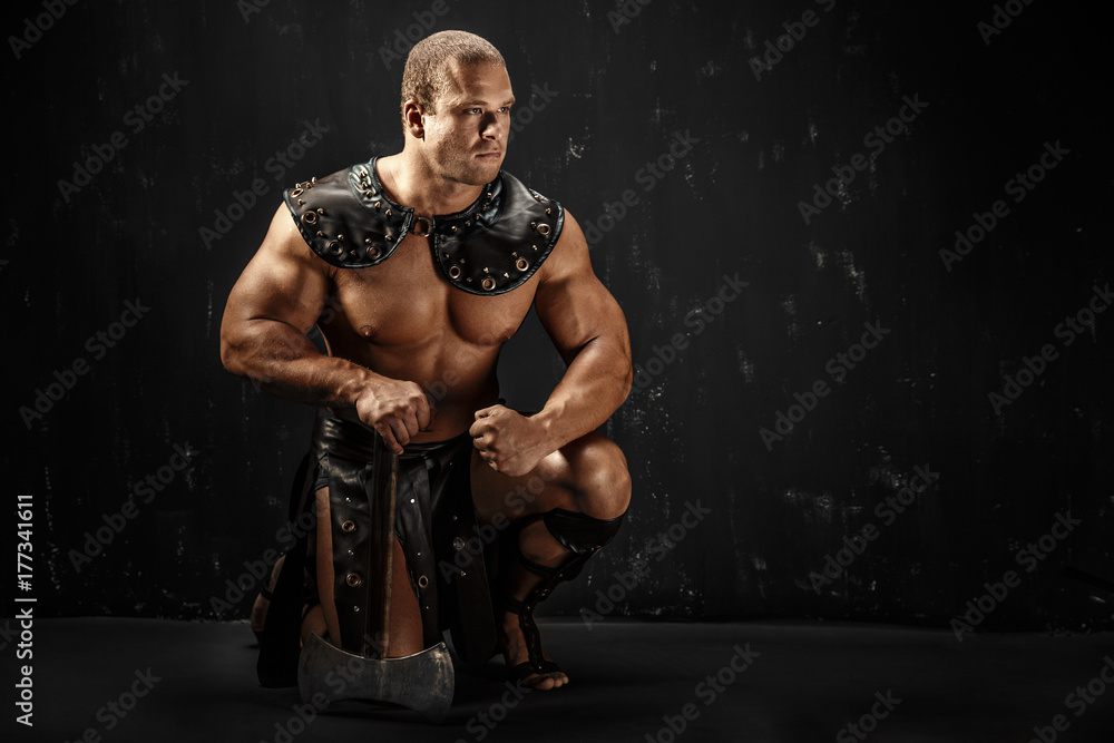Severe barbarian in leather costume with axe. Studio shot. Black ...