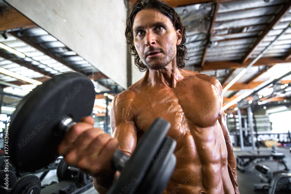 Closeup of male bodybuilding athlete with dumbbell flexing chest abs ...