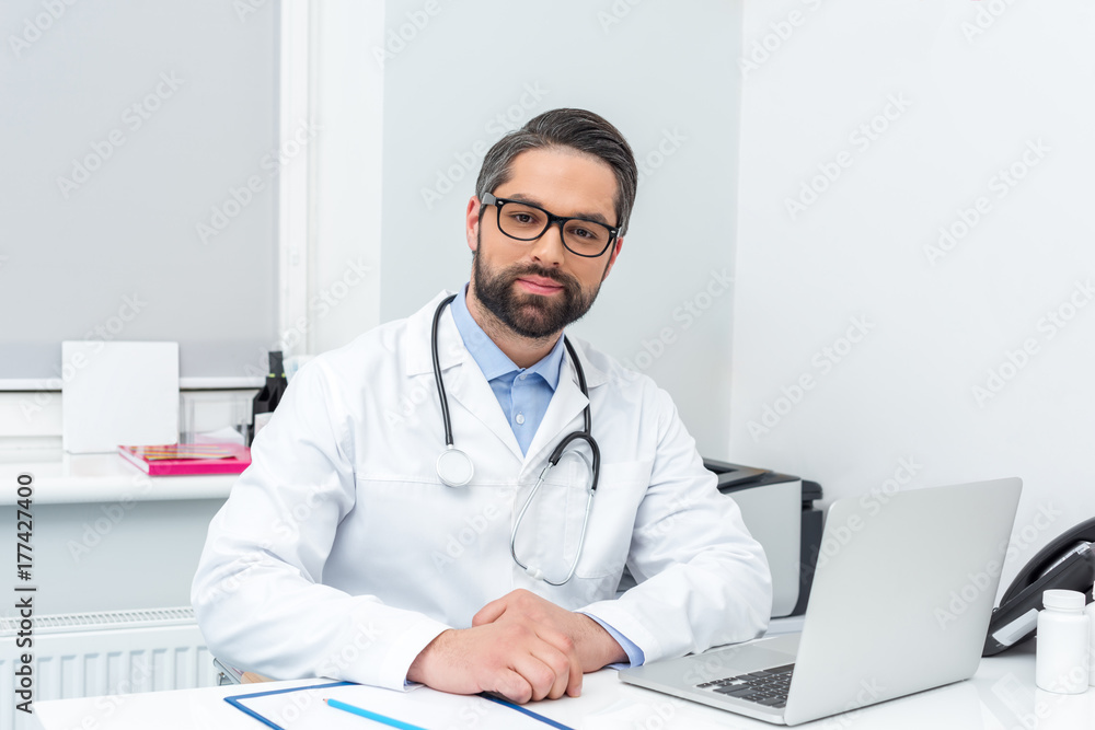 doctor sitting at workplace Stock Photo | Adobe Stock