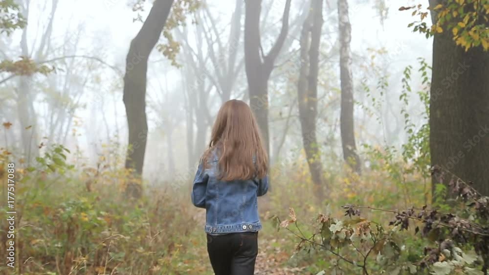Little European girl with a long hair, blue jacket, black pants ...