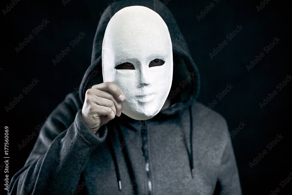 Man holding white mask for hide his face Stock Photo | Adobe Stock
