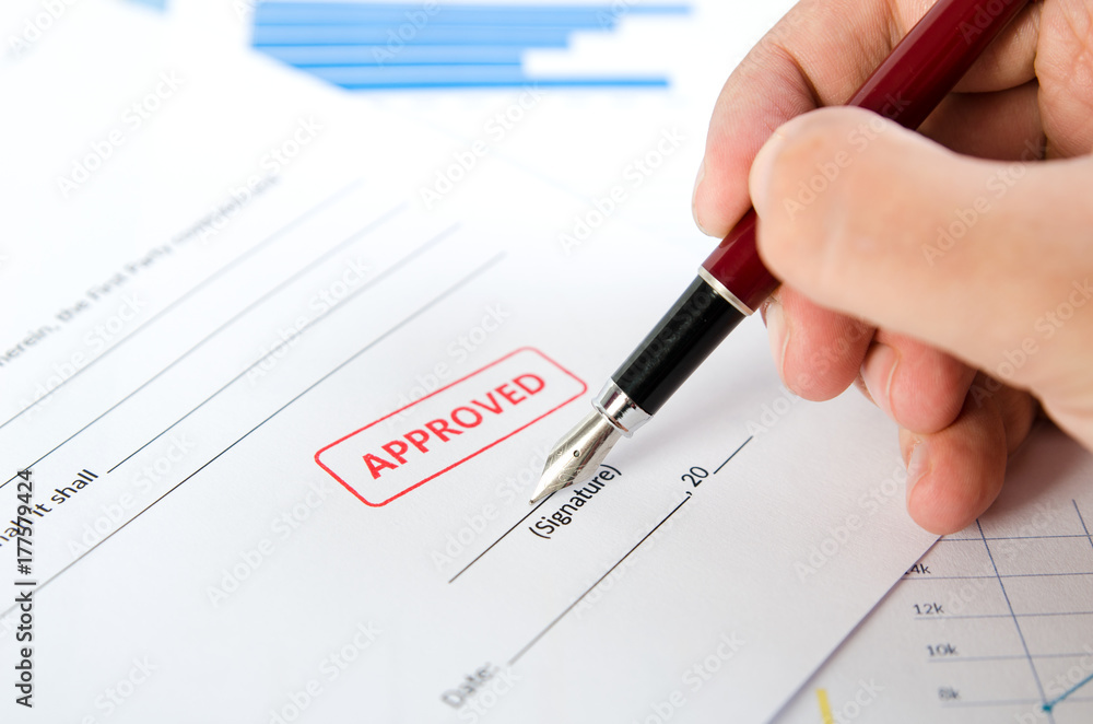 Man signs the contract with pen. Approved stamp on document Stock Photo ...