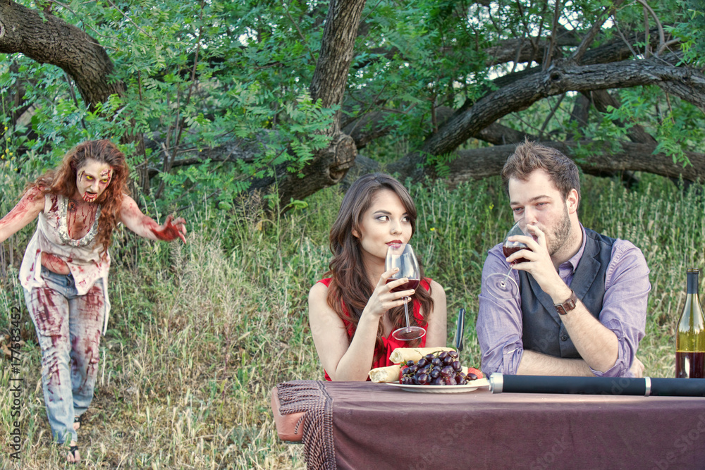 A grotesque and bloody female zombie emerges from the woods and is ...