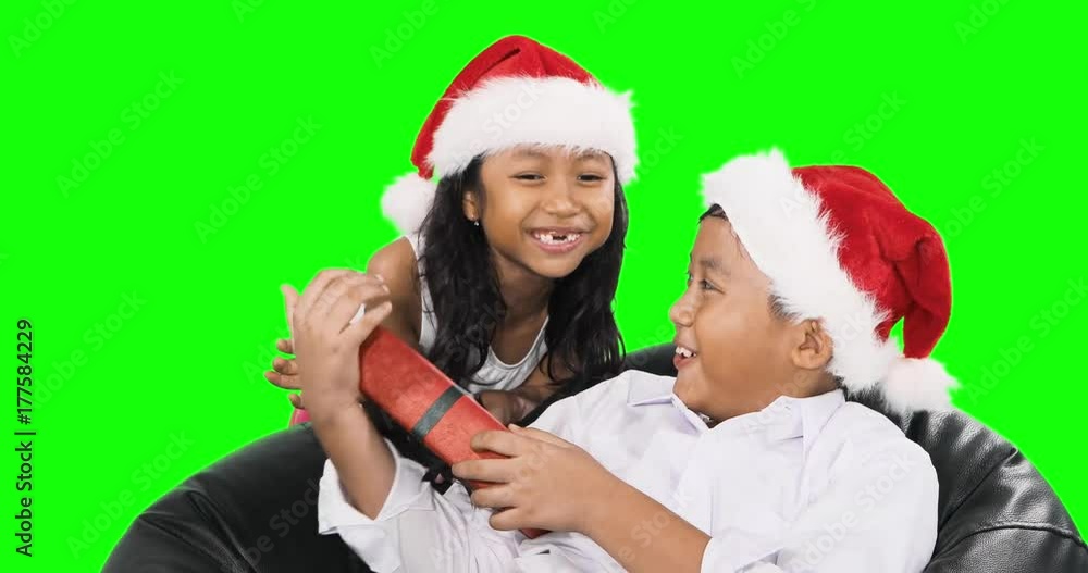 Toothless little girl giving her brother a Christmas gift while wearing ...