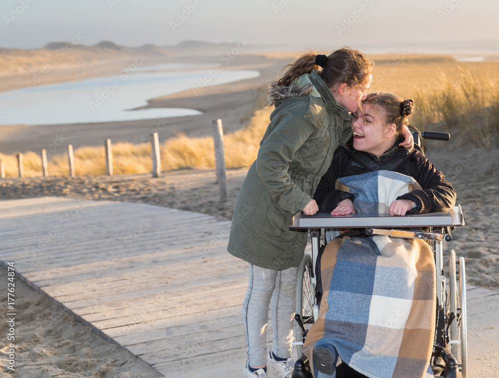 Disability a disabled girl in a wheelchair having fun at the beach with ...