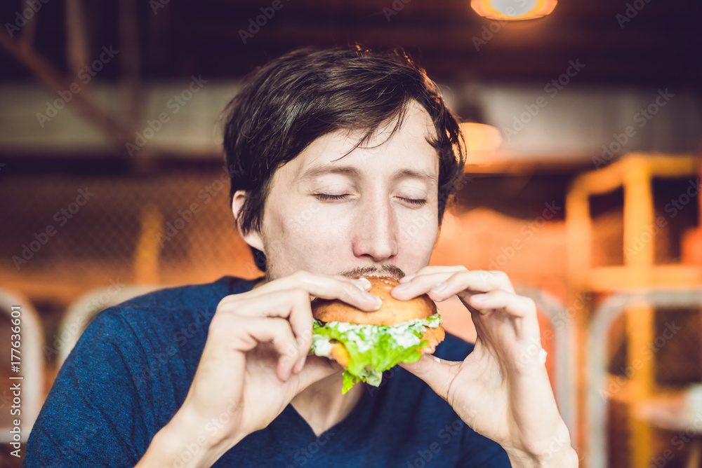 Young man eating hamburger man eating junk food, fatty food hamburger ...