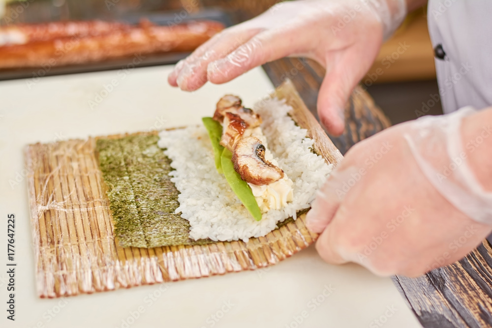 Cook hands making japanese sushi roll. The process of cooking sushi ...