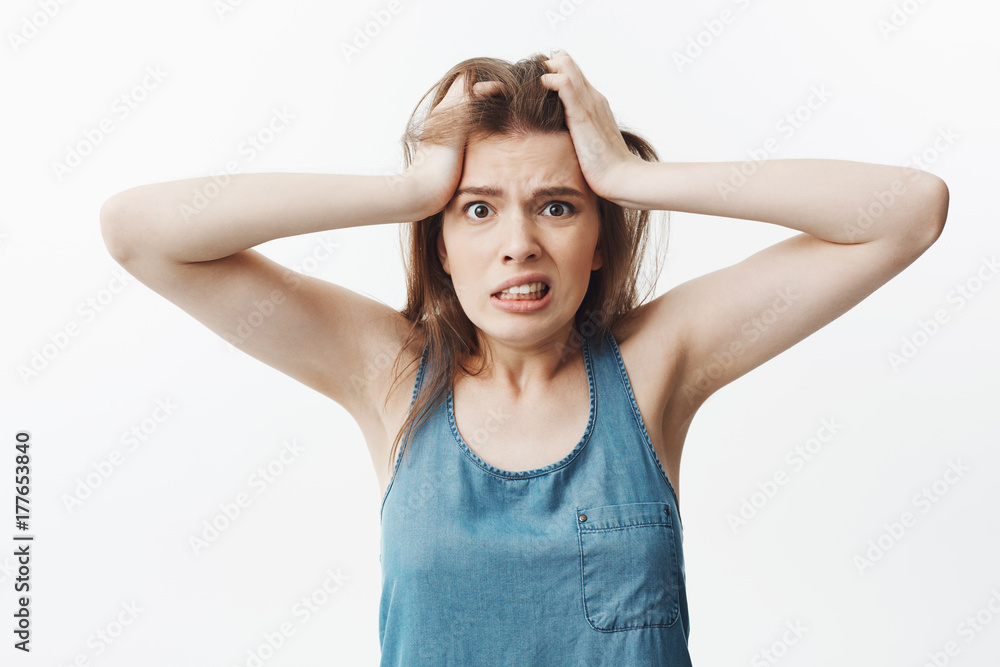 Portrait of angry young caucasian woman with dark hair in blue top ... Portrait of angry young caucasian woman with dark hair in blue top ...