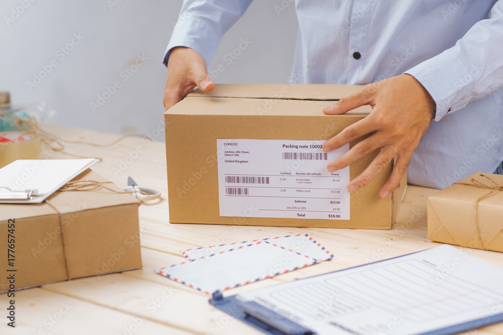 Deliveryman taping and packing cardboard box for delivery Stock Photo ...