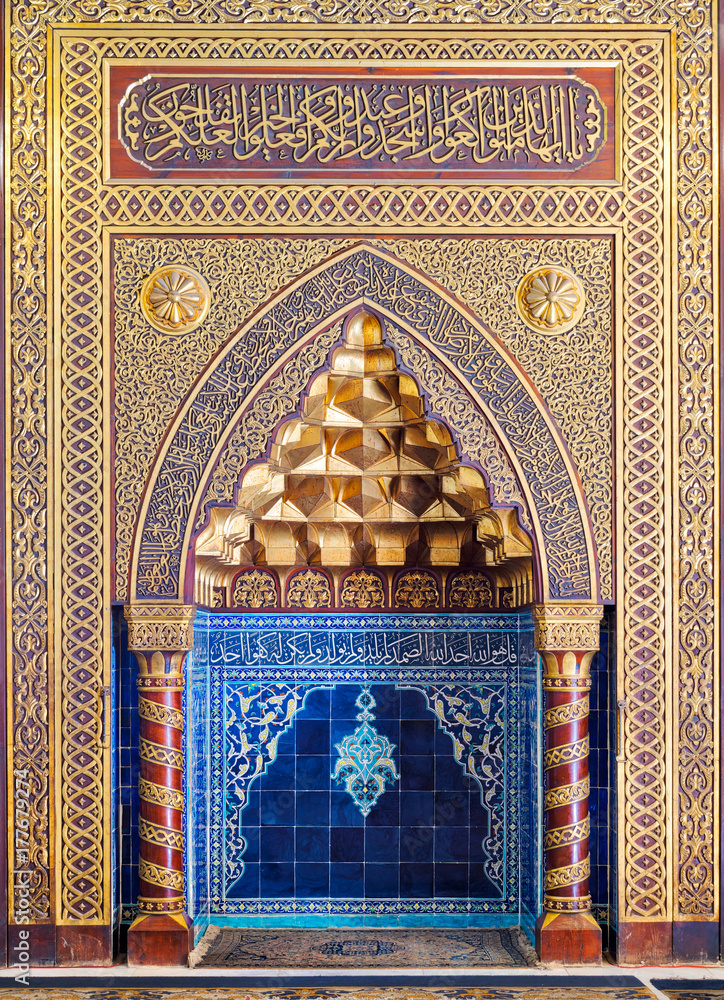 Golden ornate arched mihrab (niche) with floral pattern, blue Turkish ...