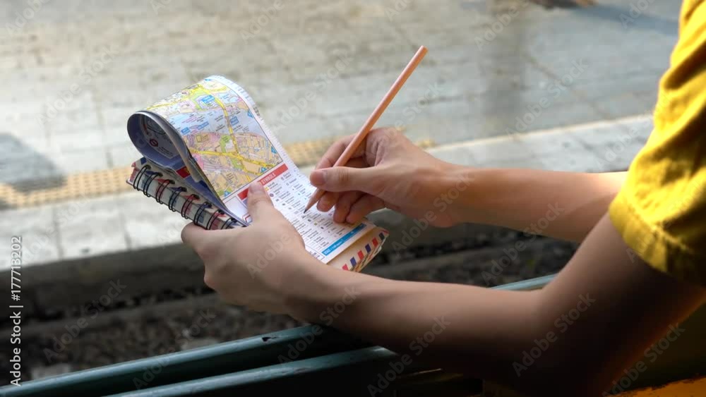 Young boy on a train writing notes in map planning for travel ...