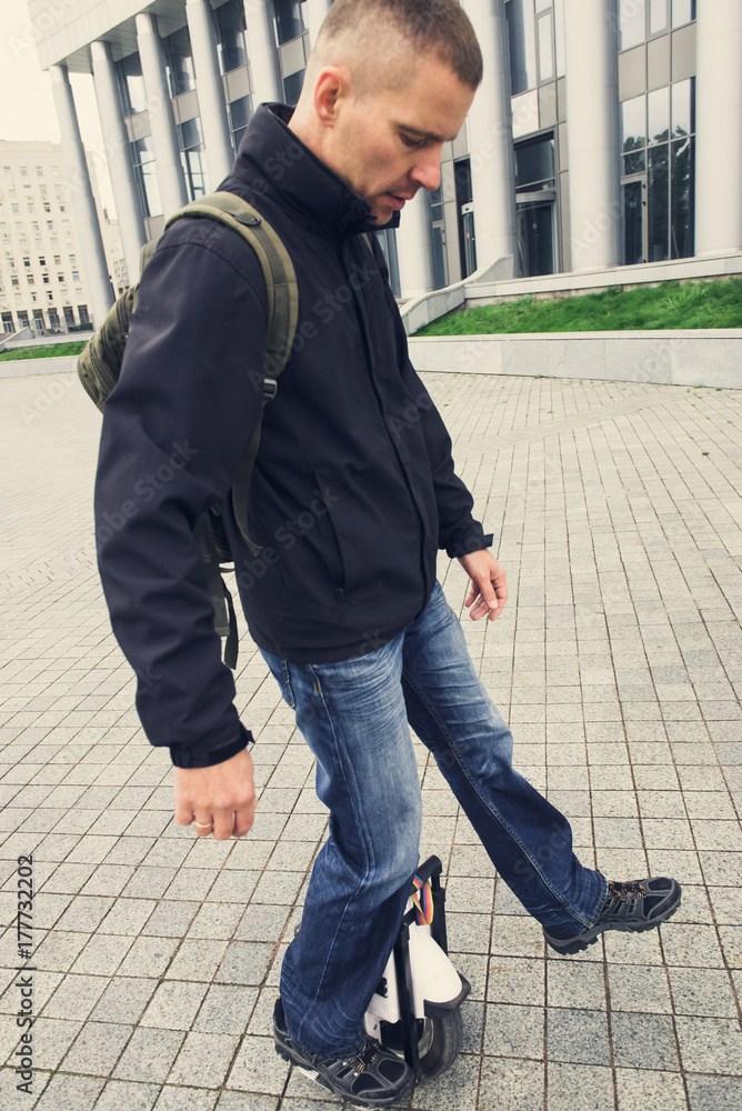 Casual man riding on one wheel electronic gyroscooter in the cit Stock ...