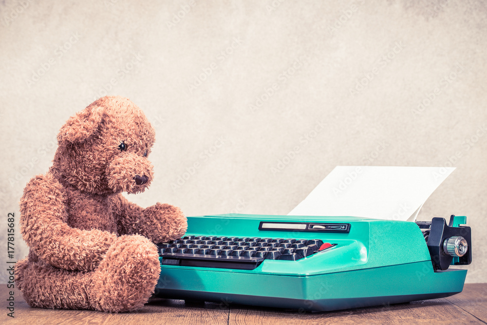 Retro Teddy Bear toy typing on old classic mint green typewriter circa ...