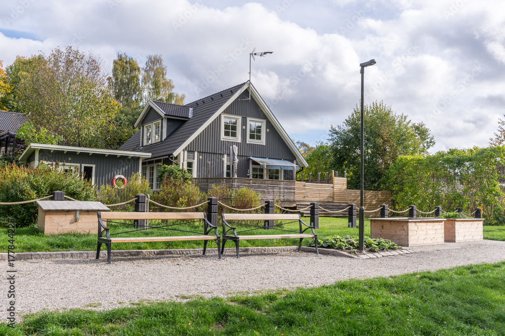 Ett fint hus med bänkar utanför vid Åkers kanal i Åkersberga Stock ...