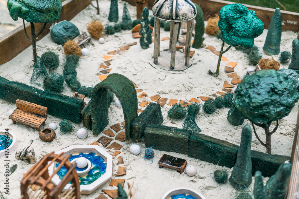 Miniature houses, toy landscape objects in sandbox. Anti-stress and ...