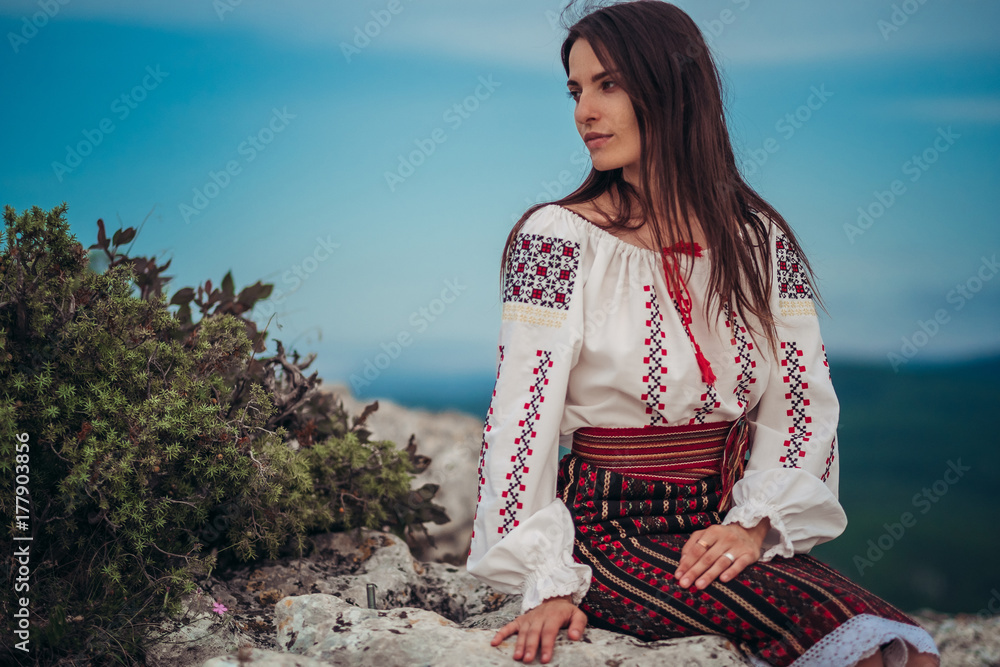 Atractive woman in traditional romanian costume on mountain green ...