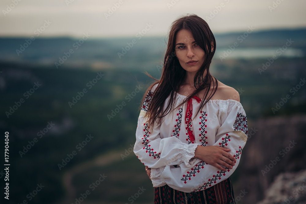 Atractive woman in traditional romanian costume on mountain green ...