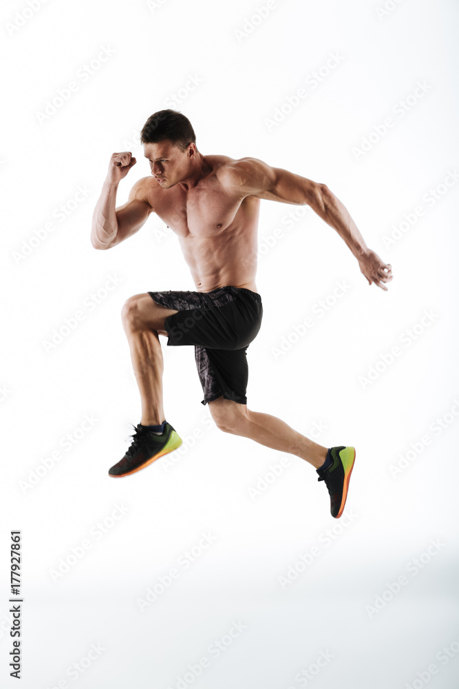 Full length photo of young powerful sports man jumping over white ...
