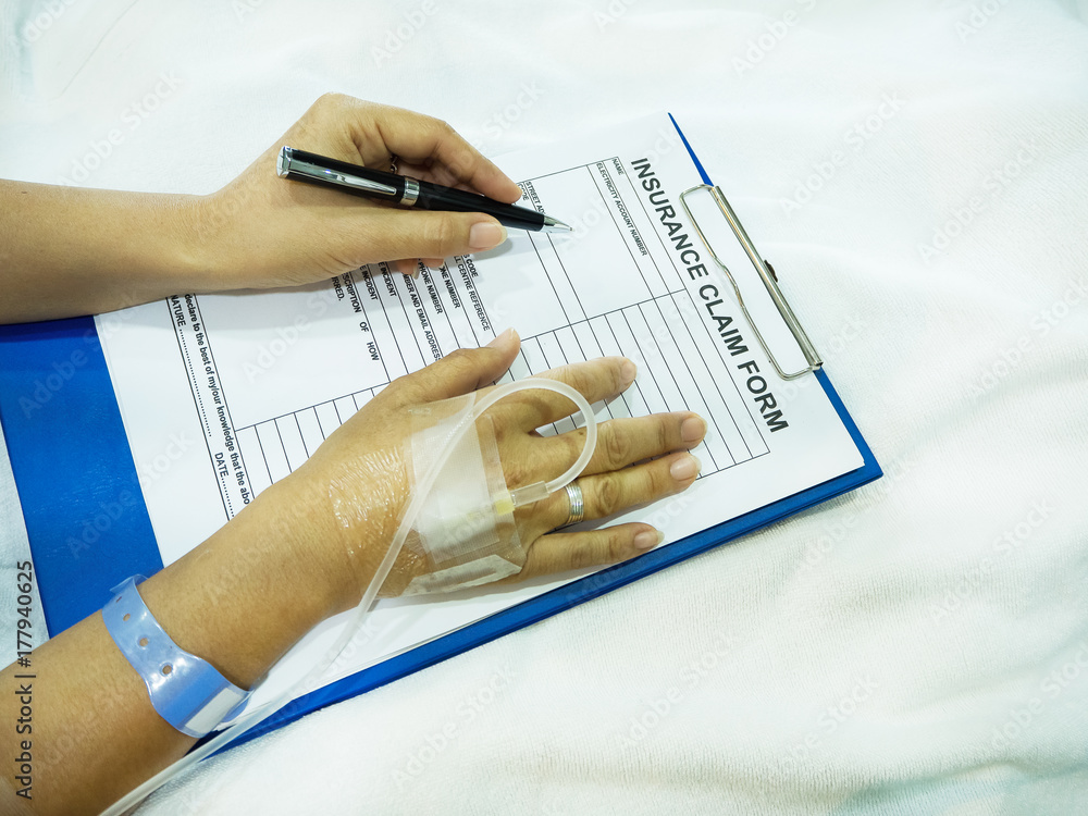 The human left hand is writing on the Insurance Claim Form with pen and ...