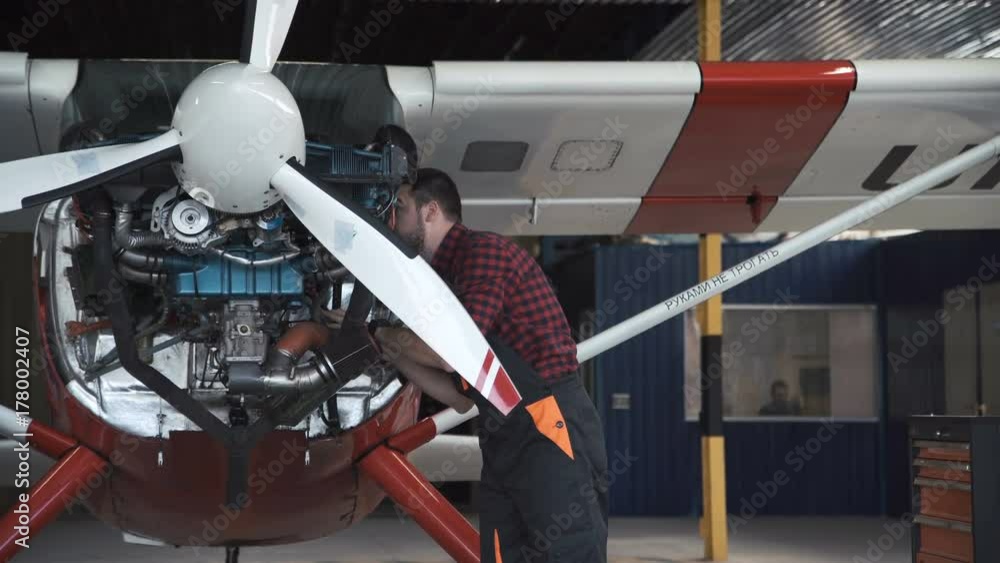 Two flight mechanics doing a pre flight check or maintenance on a small ...
