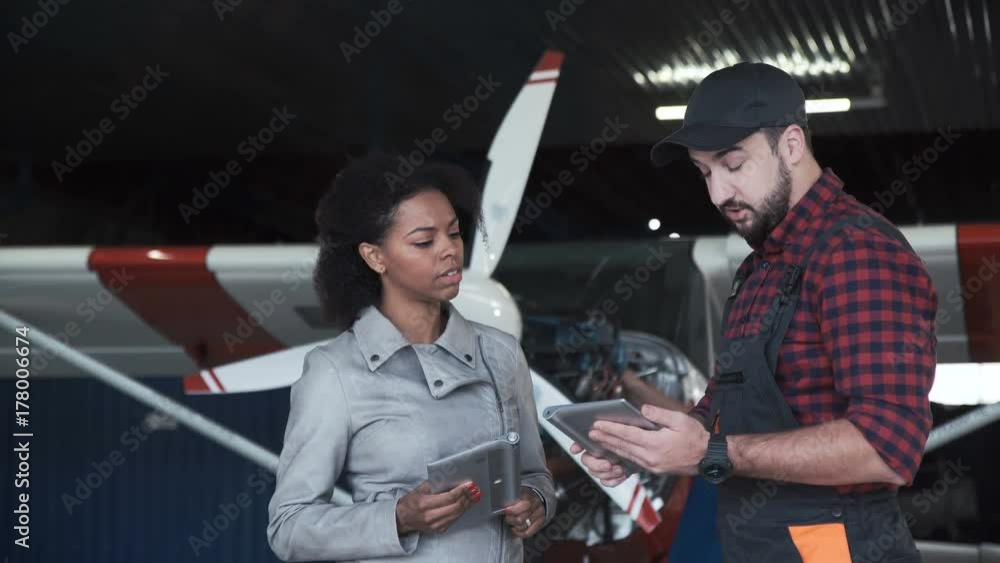 Pilot and mechanic discussing aircraft repairs or pre flight check ...