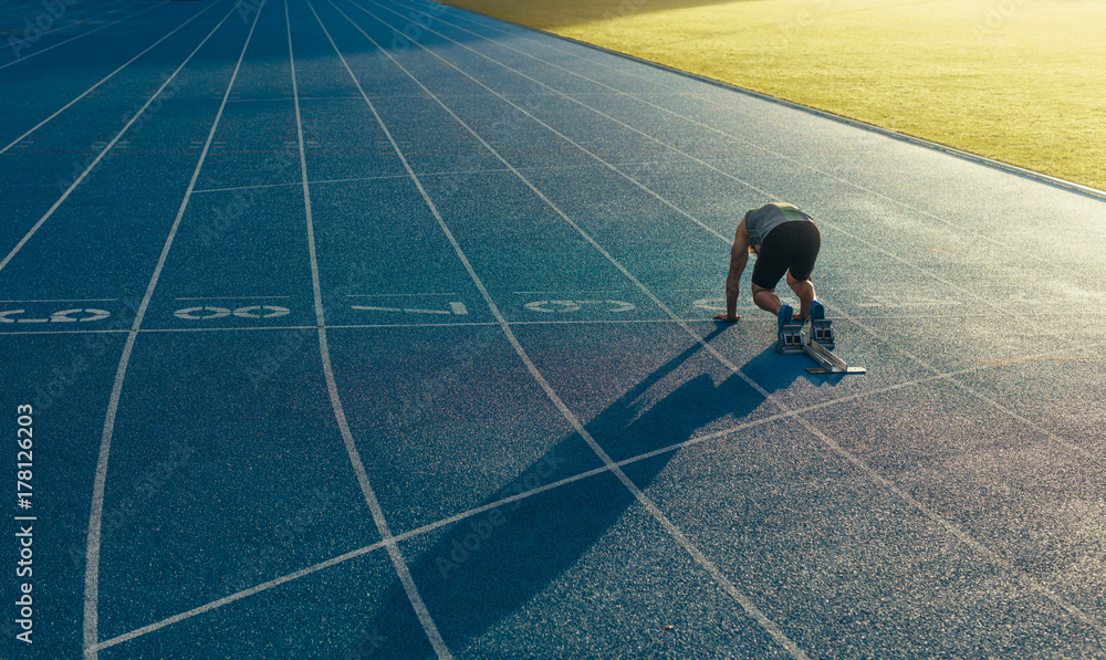 Sprinter on his marks on a running track Stock Photo | Adobe Stock