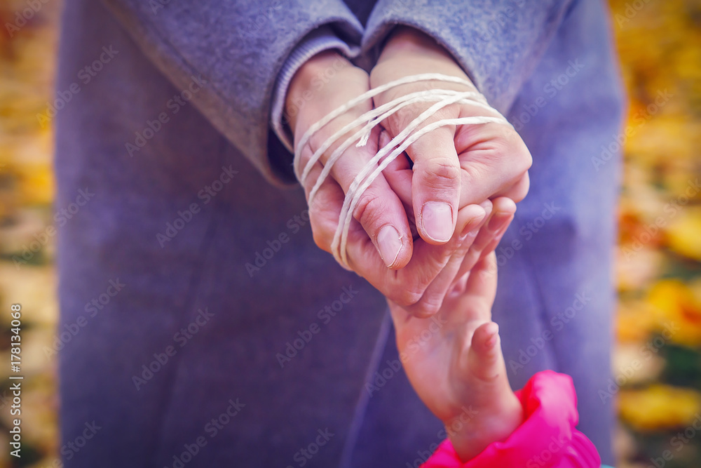 child's hand reaches out to rope-tied hands of her mother. Detention of ...