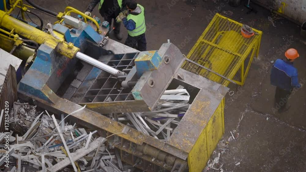 huge hydraulic scrap baling press machine is working, pressed metal ...