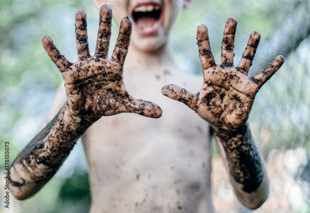 Happy, messy child shows off his very muddy hands Stock Photo | Adobe Stock