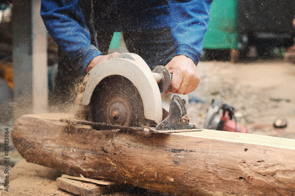carpenter using saws cutting woods at construction site Stock Photo ...