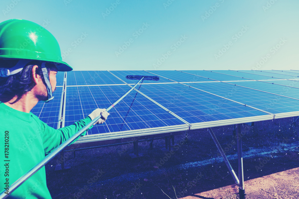 labor working on cleaning solar panel at solar power plant; operation ...
